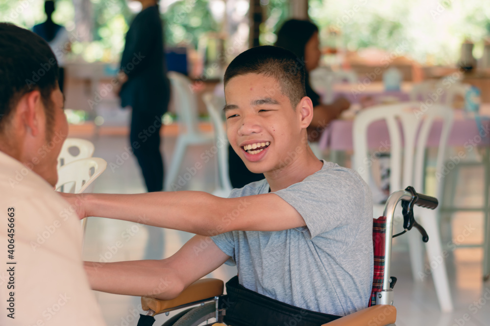 Asian special child on wheelchair smiling with happy face and hold ...