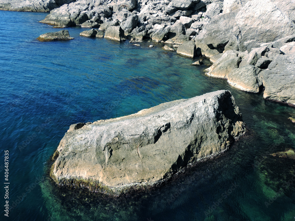tropical island a rocky bay shore with blue and turquoise clear water ...