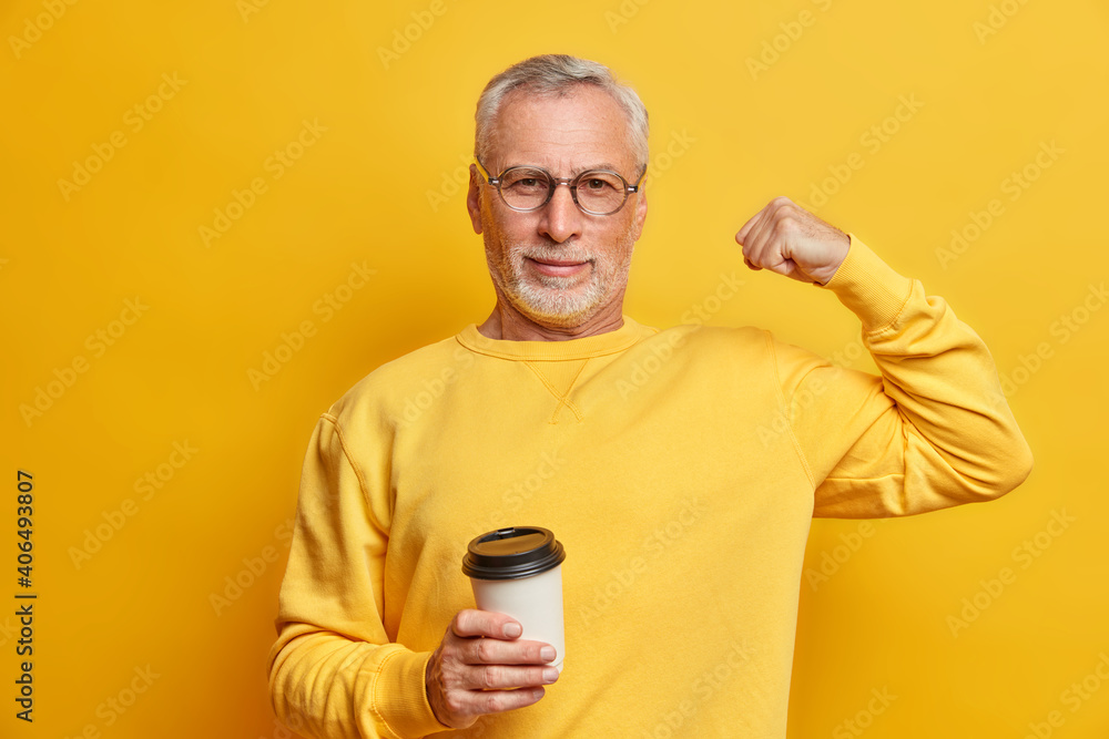 Serious self confident mature man raises arm and shows biceps being ...