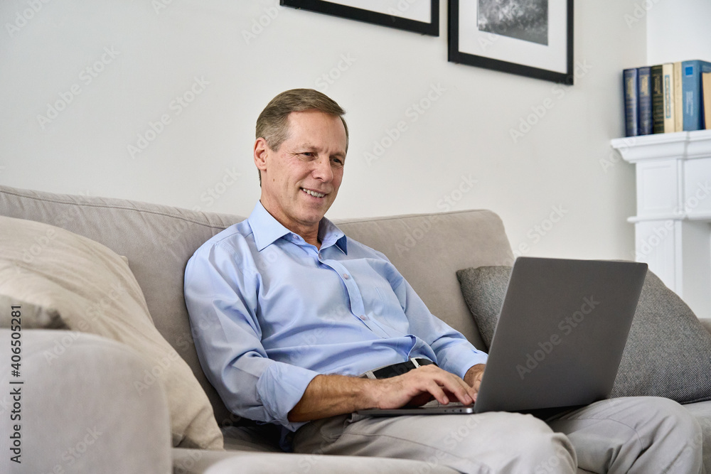 Smiling happy middle aged 50s old senior man using laptop computer ...