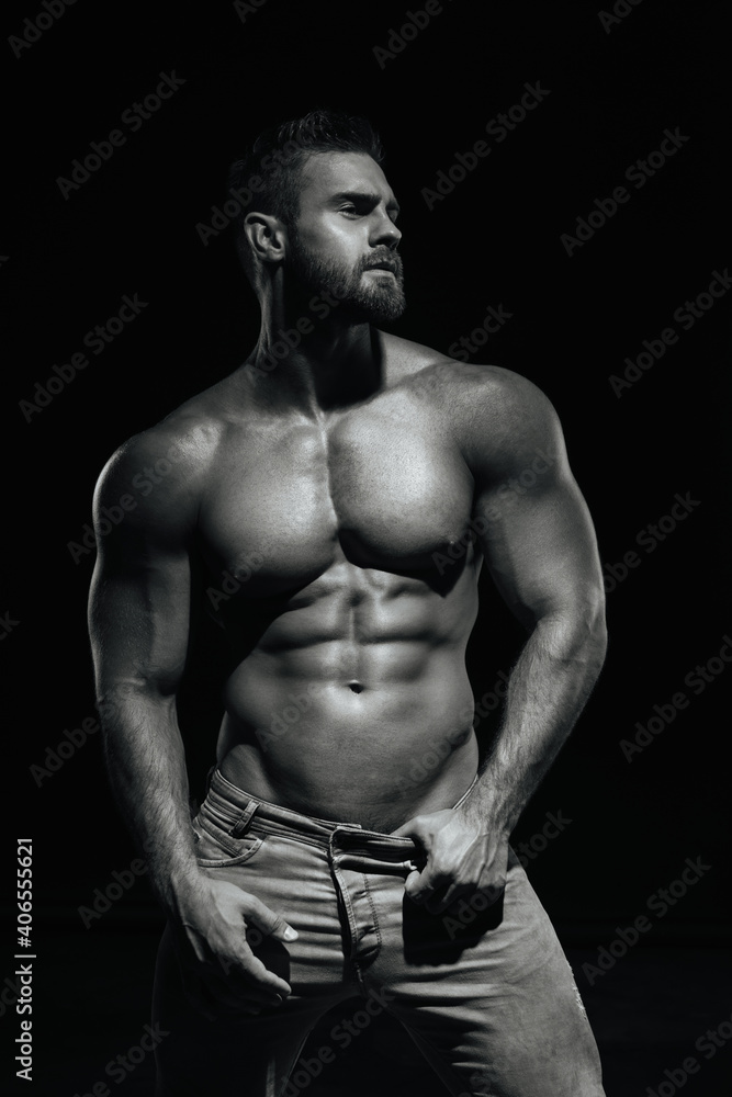 Male fitness model Konstantin Kamynin posing shirtless on black ...