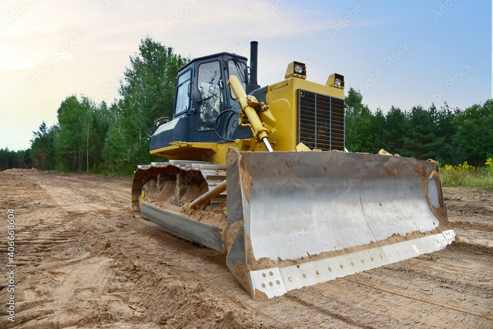 Dozer during clearing forest for construction new road . Yellow ...