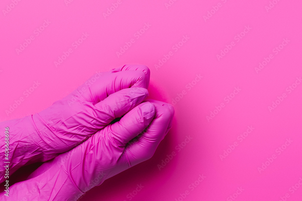 Praying hands in pink latex gloves on a pink background with empty side ...