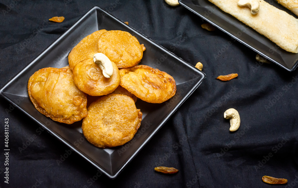 Bengali sweet - Patishapta Pitha and Malpua in a black plate on black ...