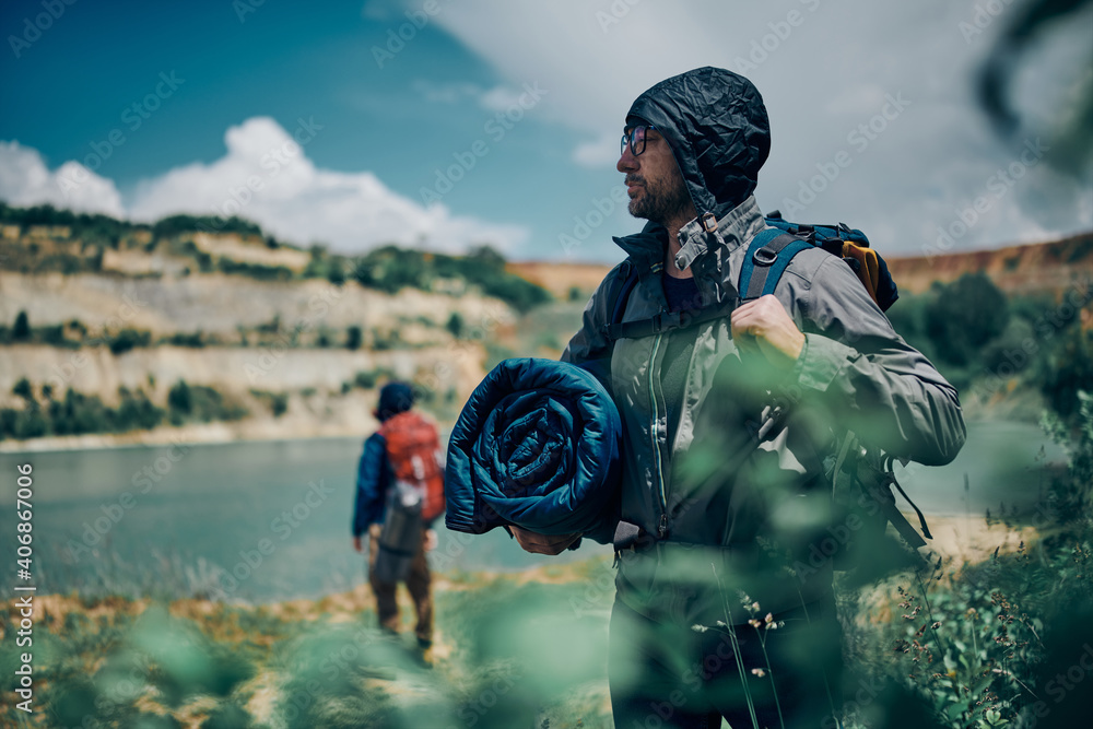 Man on a camping trip standing and looking at nature. He is having ...