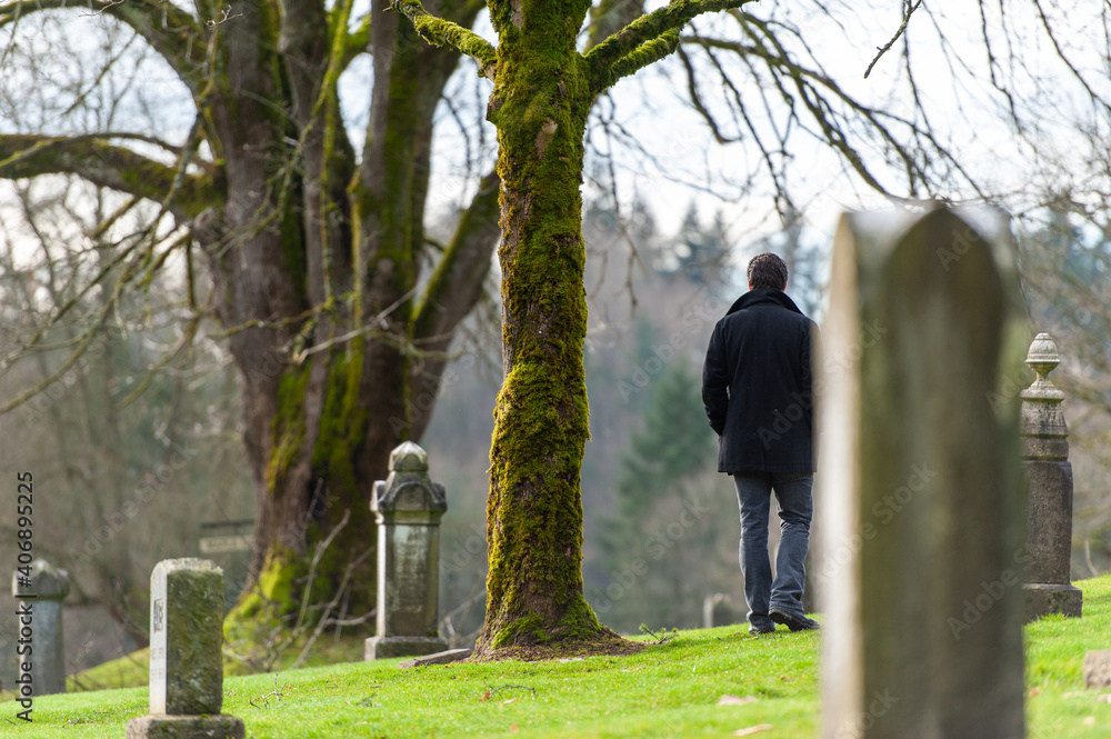 Man walking amongst headstones in old graveyard cemetery Stock Photo ...