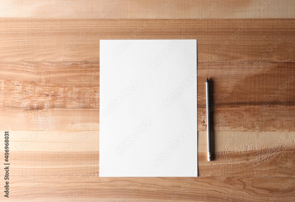 Blank paper sheet and pencil on wooden background, flat lay. Space for ...