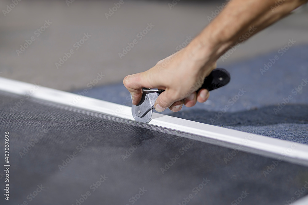 A Man putting together a window screen. You can see a man's hand with a ...