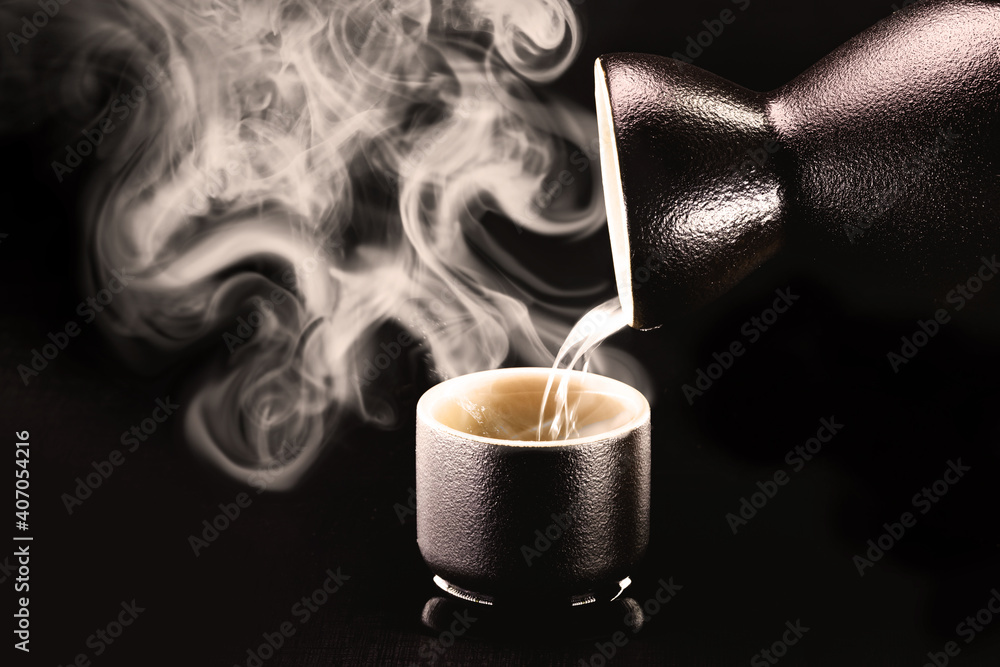 Sake, pouring traditional distilled and fermented alcohol from Japan ...