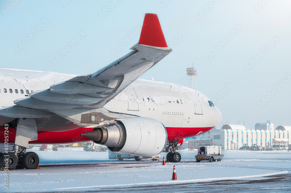 Winter scene of the airport. Modern twin-engine cargo airplane stand at ...