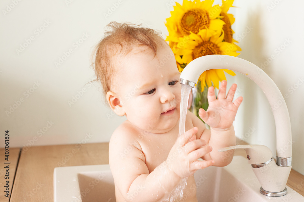 Baby taking bath in kitchen sink. Little boy bathing. Water fun for ...