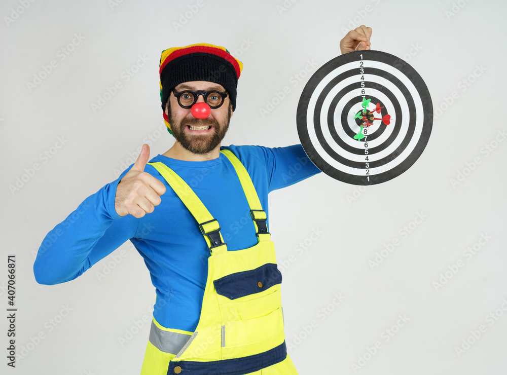 The clown holds a target in his hands, shows the result of dart ...