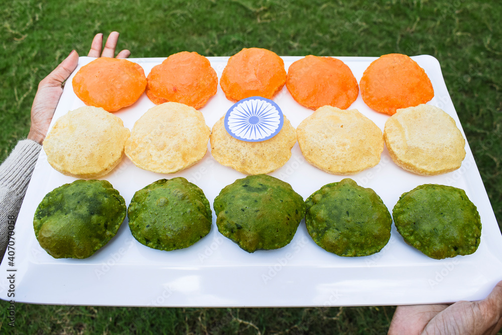 Foto de Female holding homemade colourful puris made from spinach ...