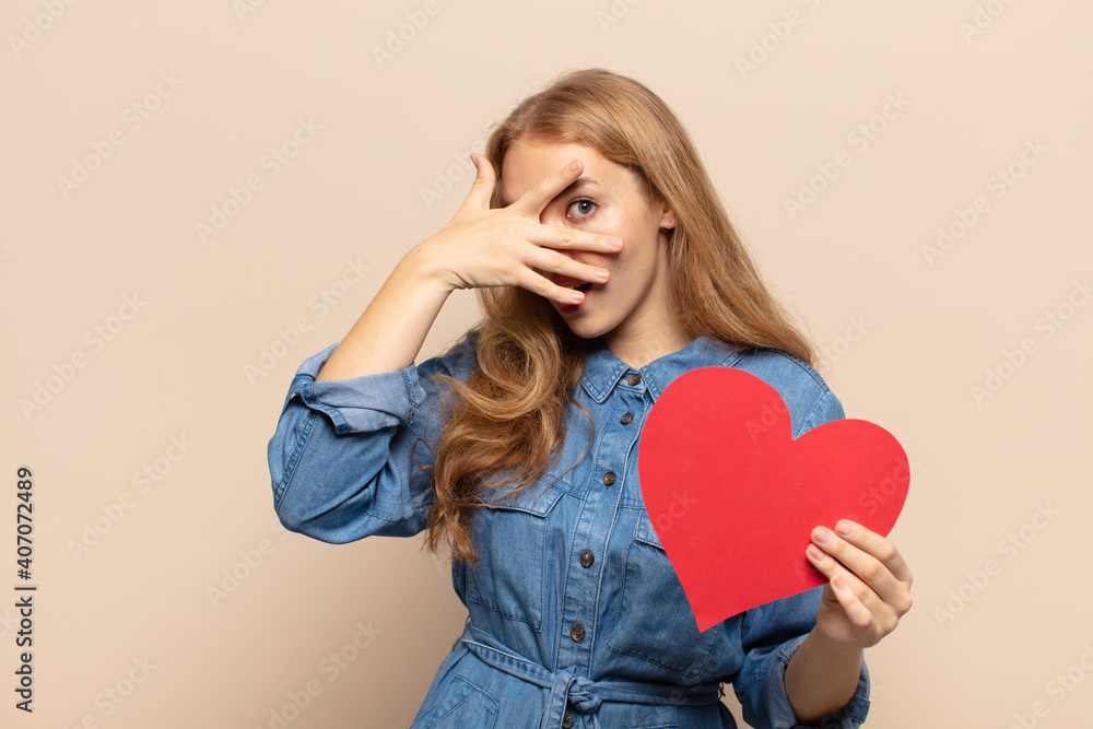 blonde woman looking shocked, scared or terrified, covering face with ...