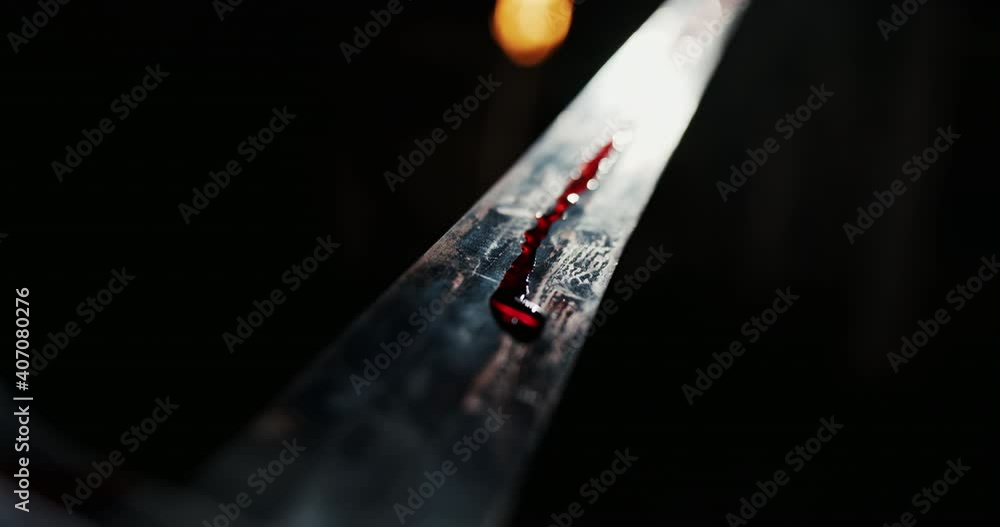 Sword with blood against the background of night and bright light that ...