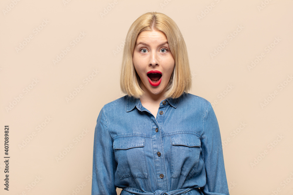 blonde woman feeling terrified and shocked, with mouth wide open in ...