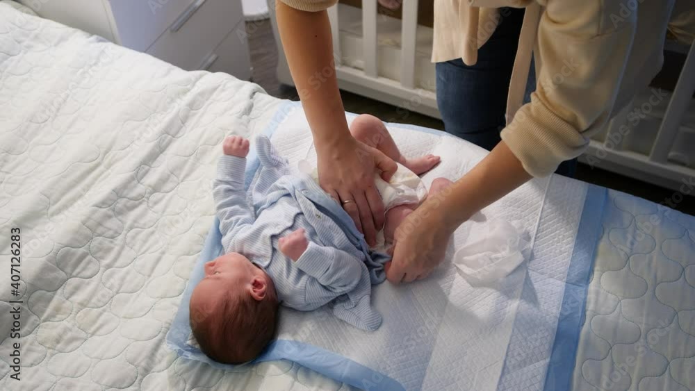 Top view of young caring mother changing messy diapers of her newborn ...