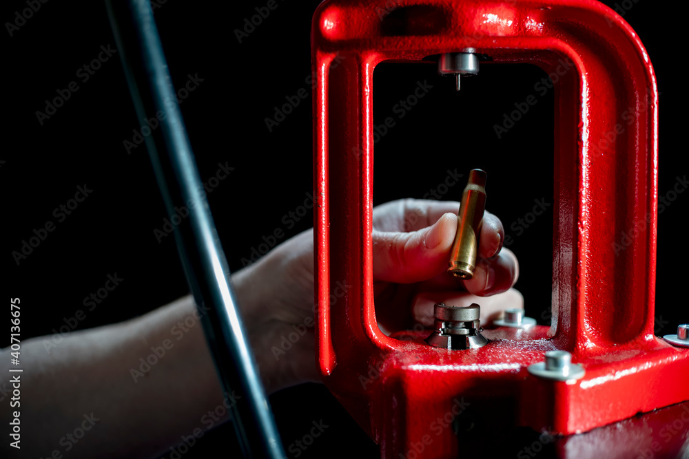 Red hand press and ammo shell against dark background, soft focus. Copy ...