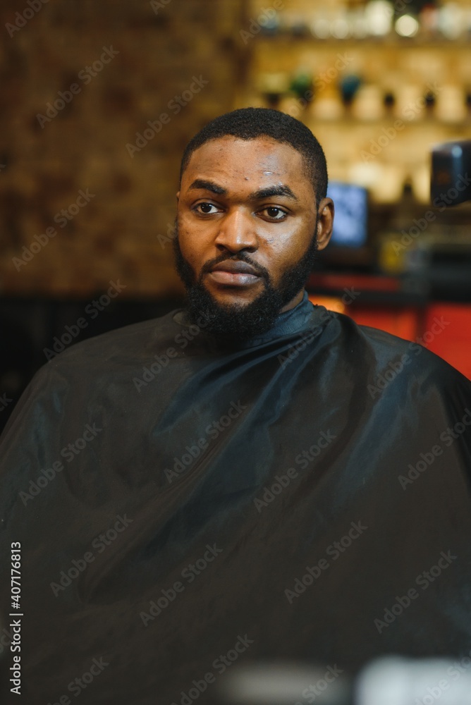 Black man in the barbershop. Cute black man makes a haircut in the ...