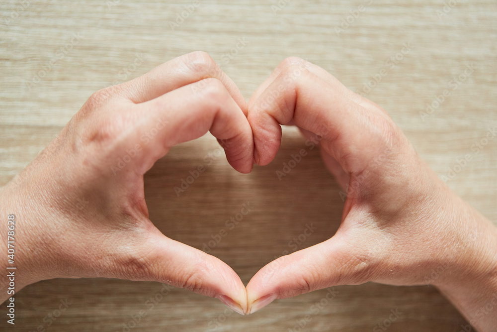 Person shapes their hands into a heart Stock Photo | Adobe Stock