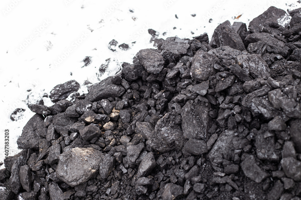 Coarse coal in the snow in winter. Maintaining high temperatures in ...