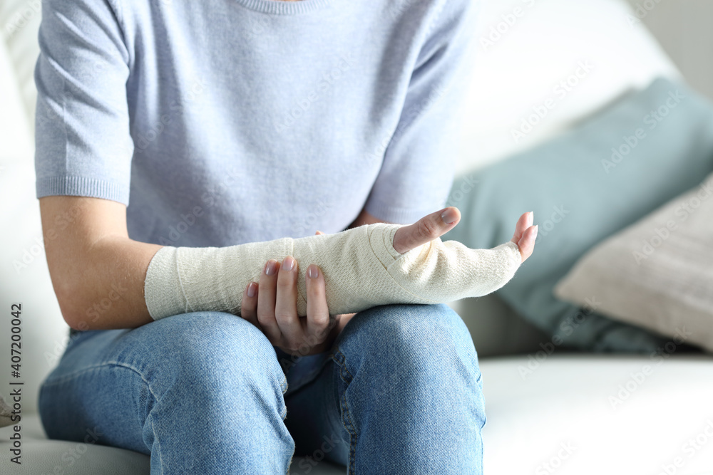 Disabled woman grabbing her painful bandaged arm Stock Photo | Adobe Stock