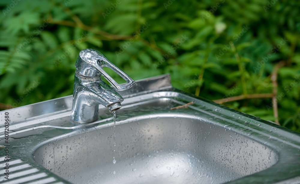 Defective faucet. Cause wastage of water. Water tap outdoor green park ...