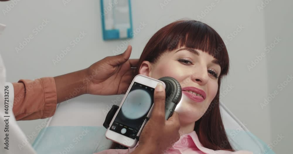 The dermatologist examines the skin. A dermatologist examines a mole on ...