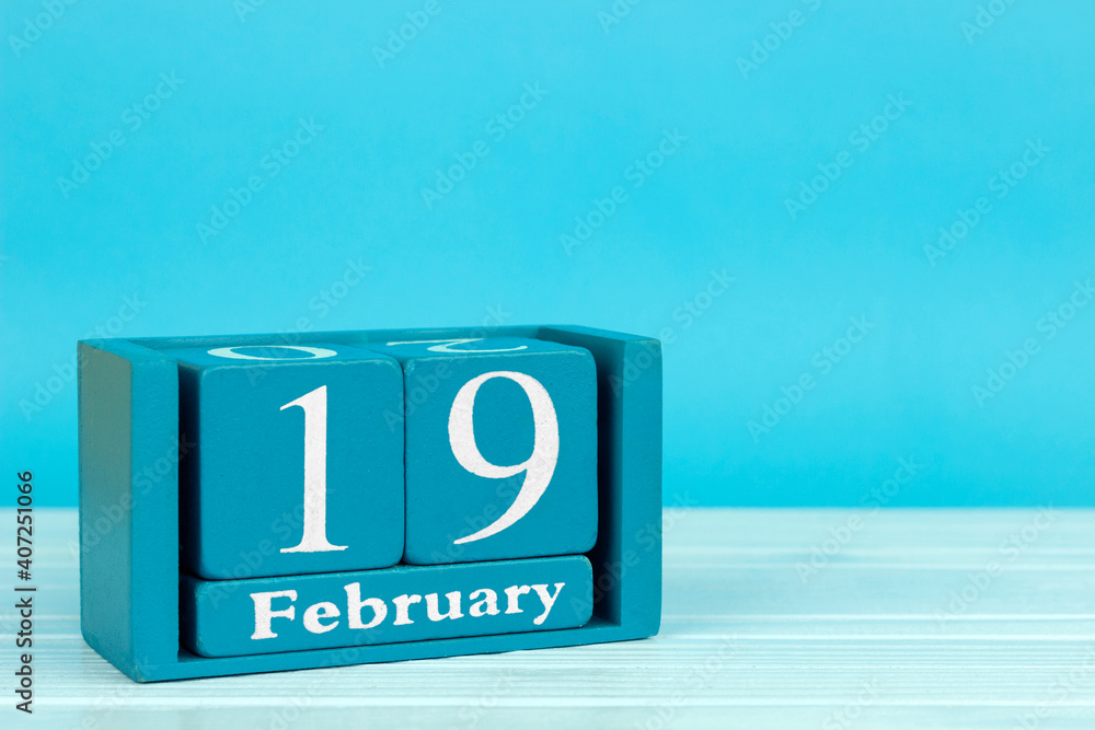 wooden calendar with the date of February 19 on a blue wooden ...