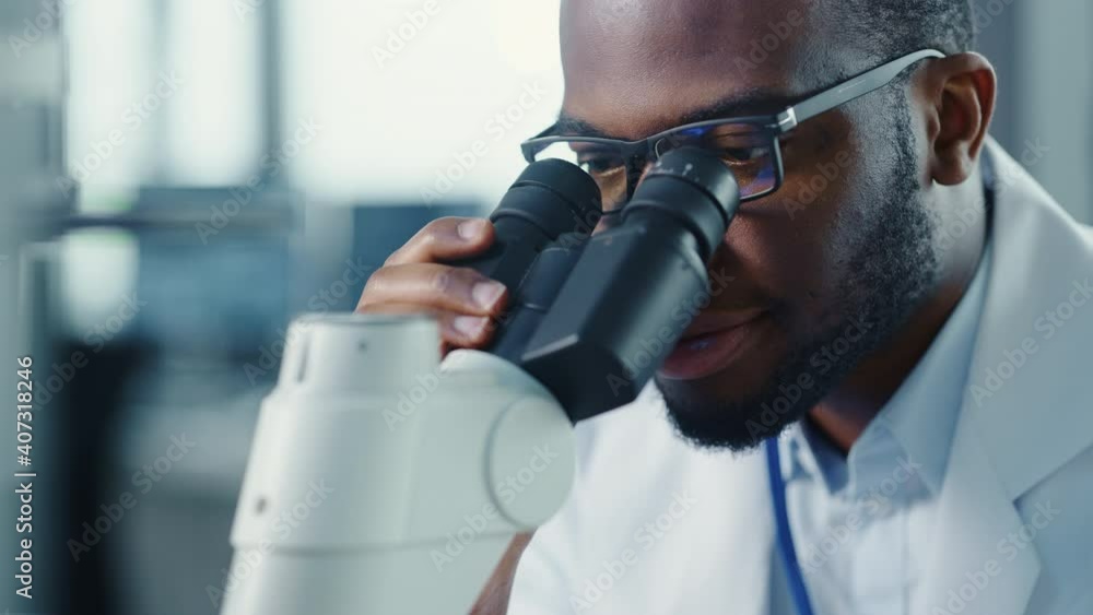 Close Up Footage of a Black Male Scientist Putting a Petri Dish with ...