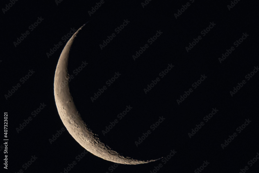 Bright partial moon photographed with craters in view on a black ...