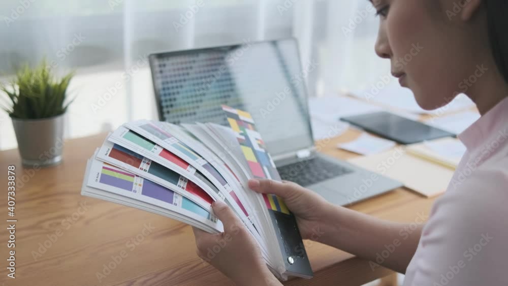 Asian woman Designer choosing color samples pallet from chart strips ...