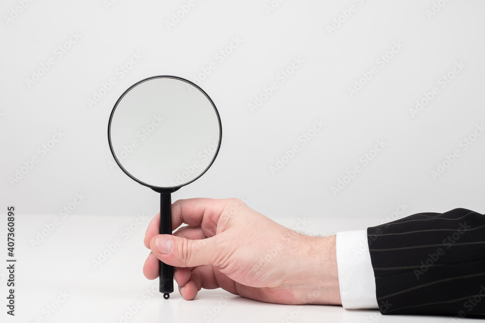 Man holds a magnifying glass. Man shows a magnifier. Concept - it shows ...