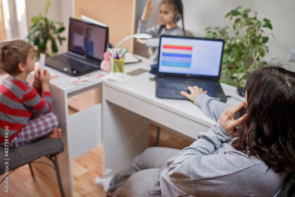 Foto de Distant education at home, children doing homework and mother ...