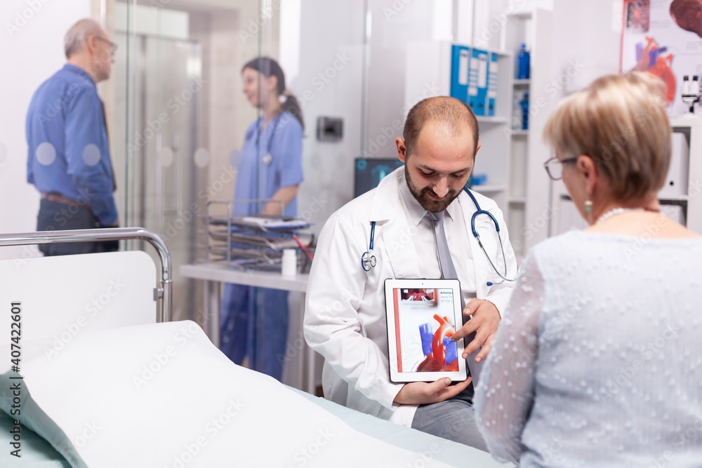 Doctor explaining treatment for heart illness to senior woman in ...