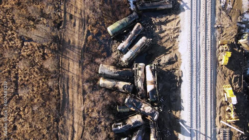 A train wreck on the railroad, scattered cisterns, tractors are ...