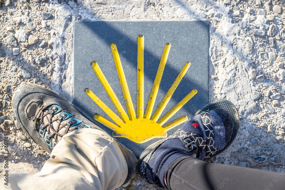Hiking Boots Feet on Pilgrim Trail with Scallop Shell Way Mark on the ...