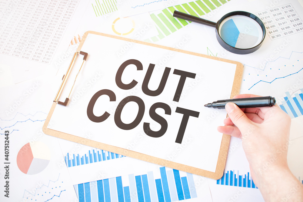 Text cut cost on white paper sheet and marker on businessman hand on ...