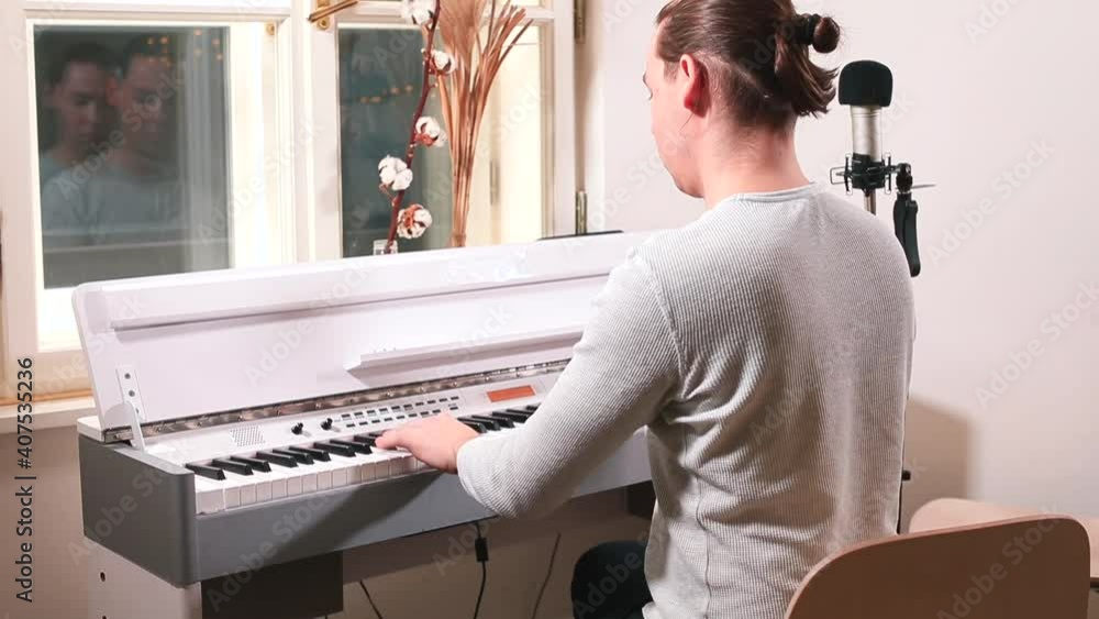 A talented composer plays the piano with his hands pressing keys ...