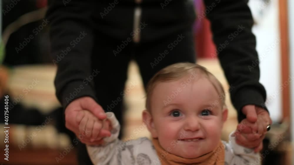 Video of a man holding toddler, as he learns how to walk, little kid is ...