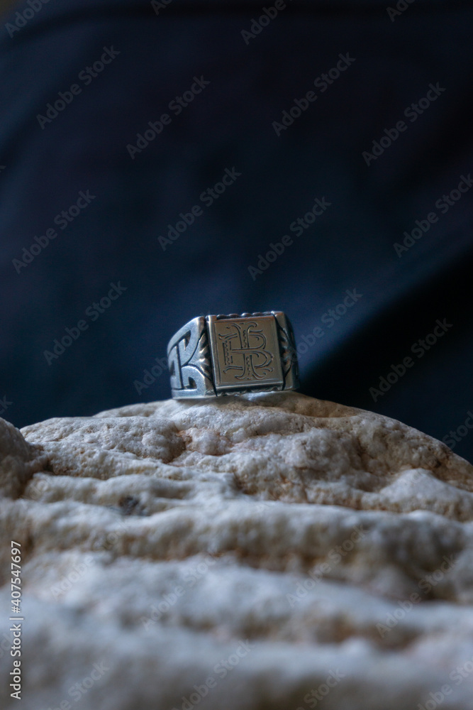 Silver ring with a dark fabric background, the ring has a background ...