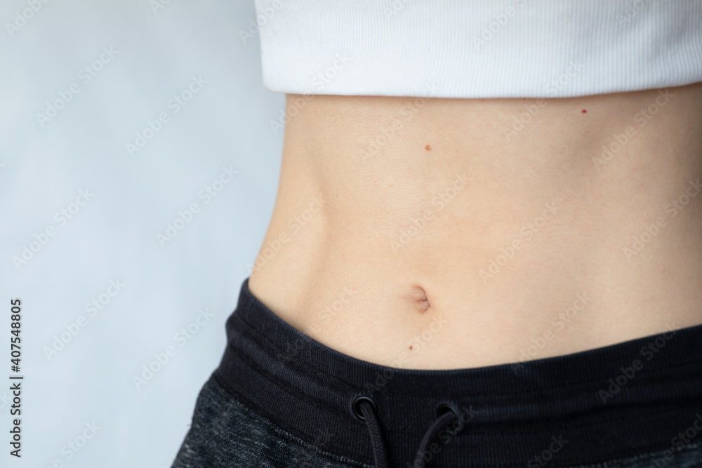 Flat female belly. Woman showing her flat belly. Body parts: athletic ...