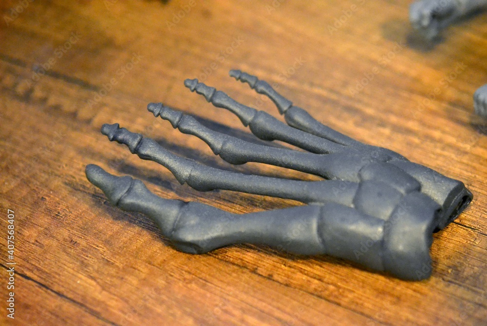 Gray prototype of the human foot skeleton printed on 3d printer on dark ...