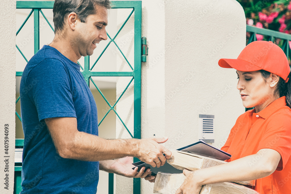 Caucasian man receiving his order from deliverywoman. Latin courier ...