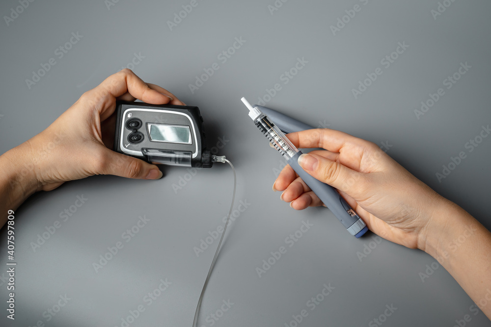 young woman holds an insulin syringe and an insulin pump in her hands ...