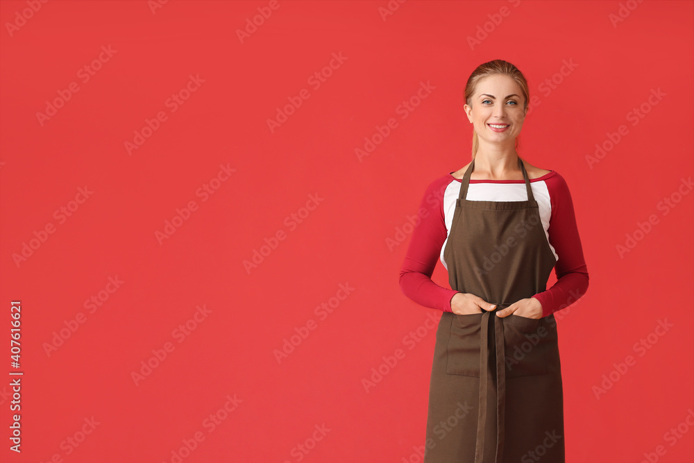 Beautiful young woman wearing apron on color background Stock Photo ...