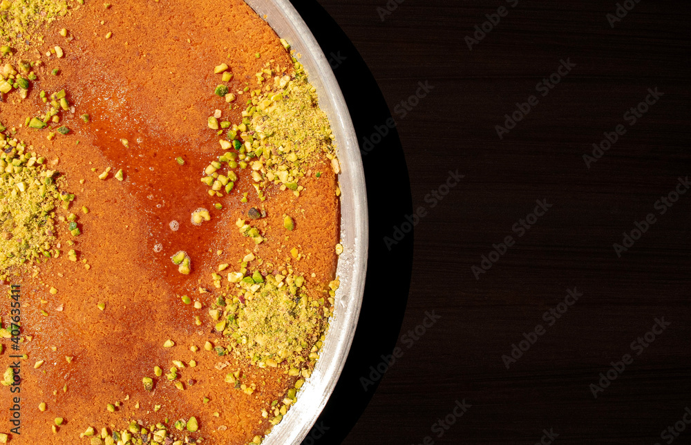 Traditional eastern dessert kunafa in a big aluminium dish on dark ...