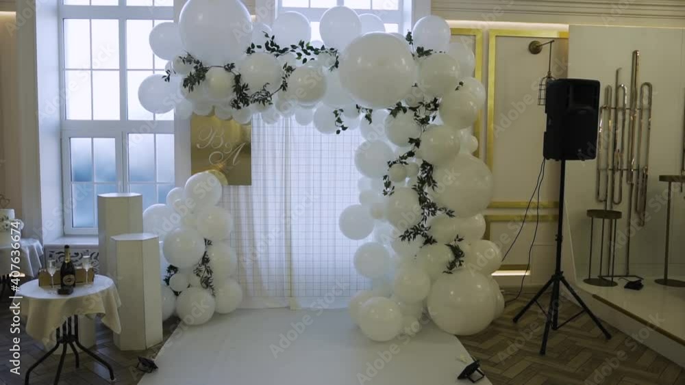 Exquisite wedding arch made of white balloons and branches of green ...