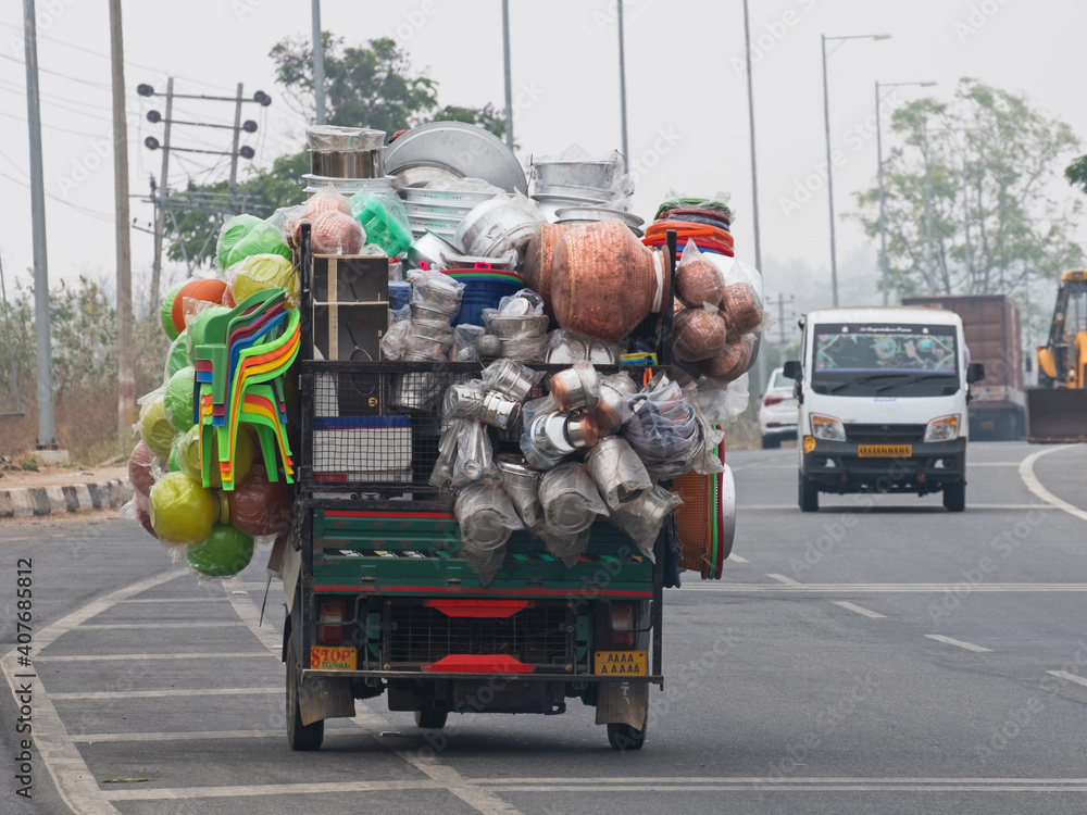 Overloaded commercial vehicle carrying household goods on a main ...
