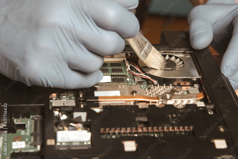 Laptop repair. Dust cleaning. An engineer cleans a computer. Stock ...
